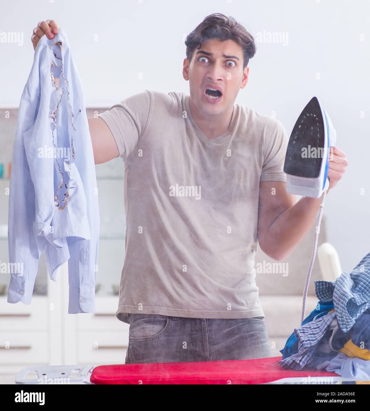 Inattentive husband burning clothing while ironing Stock Photo - Alamy