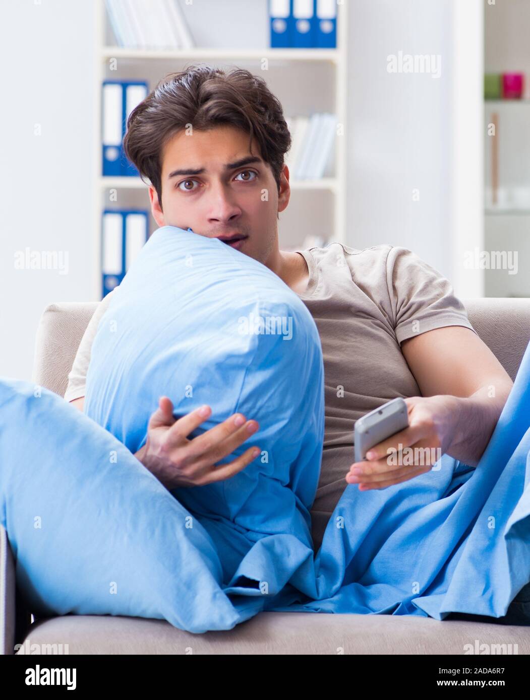 Man watching tv from bed holding remote control unit Stock Photo - Alamy