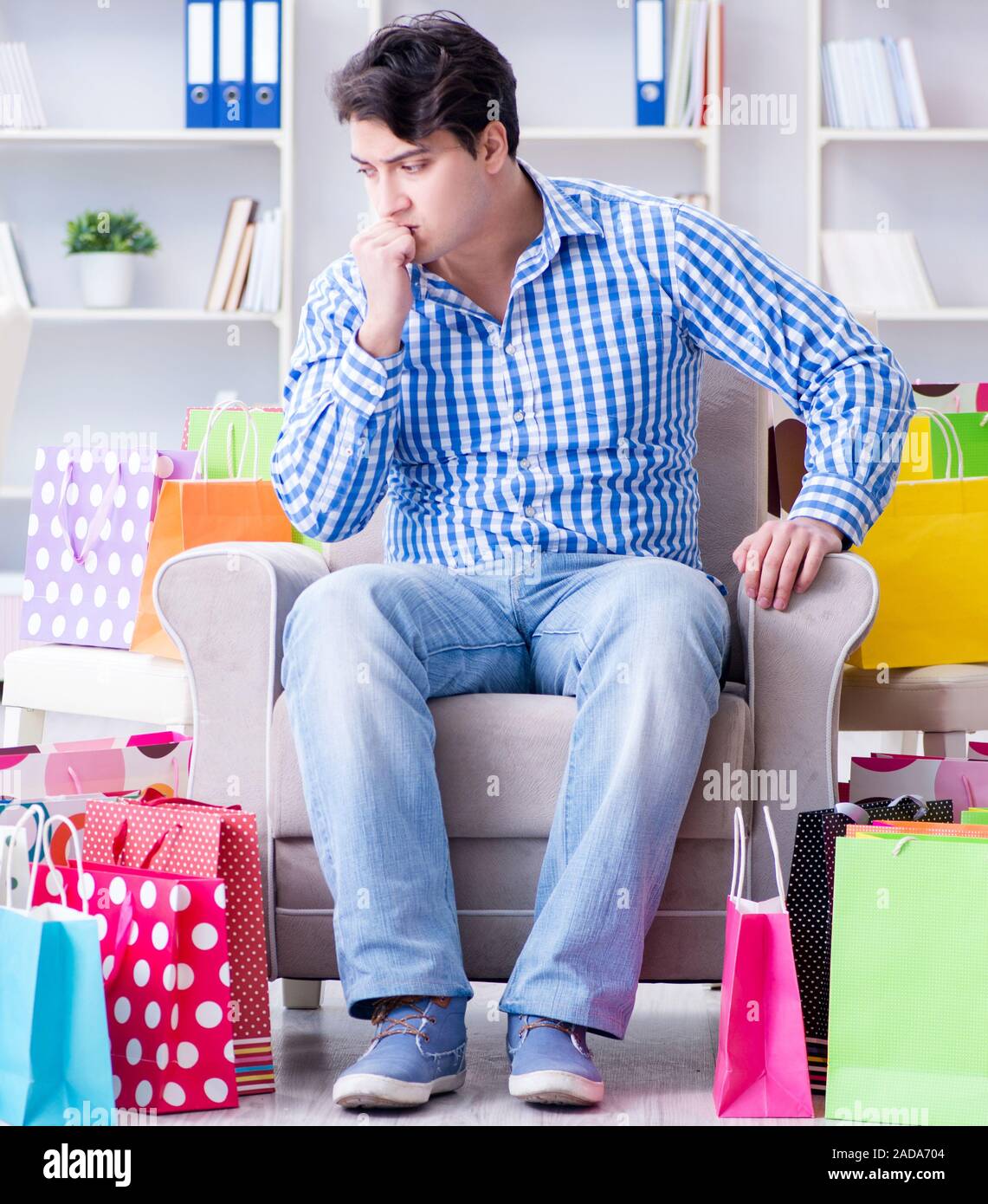 Young man after excessive shopping at home Stock Photo - Alamy