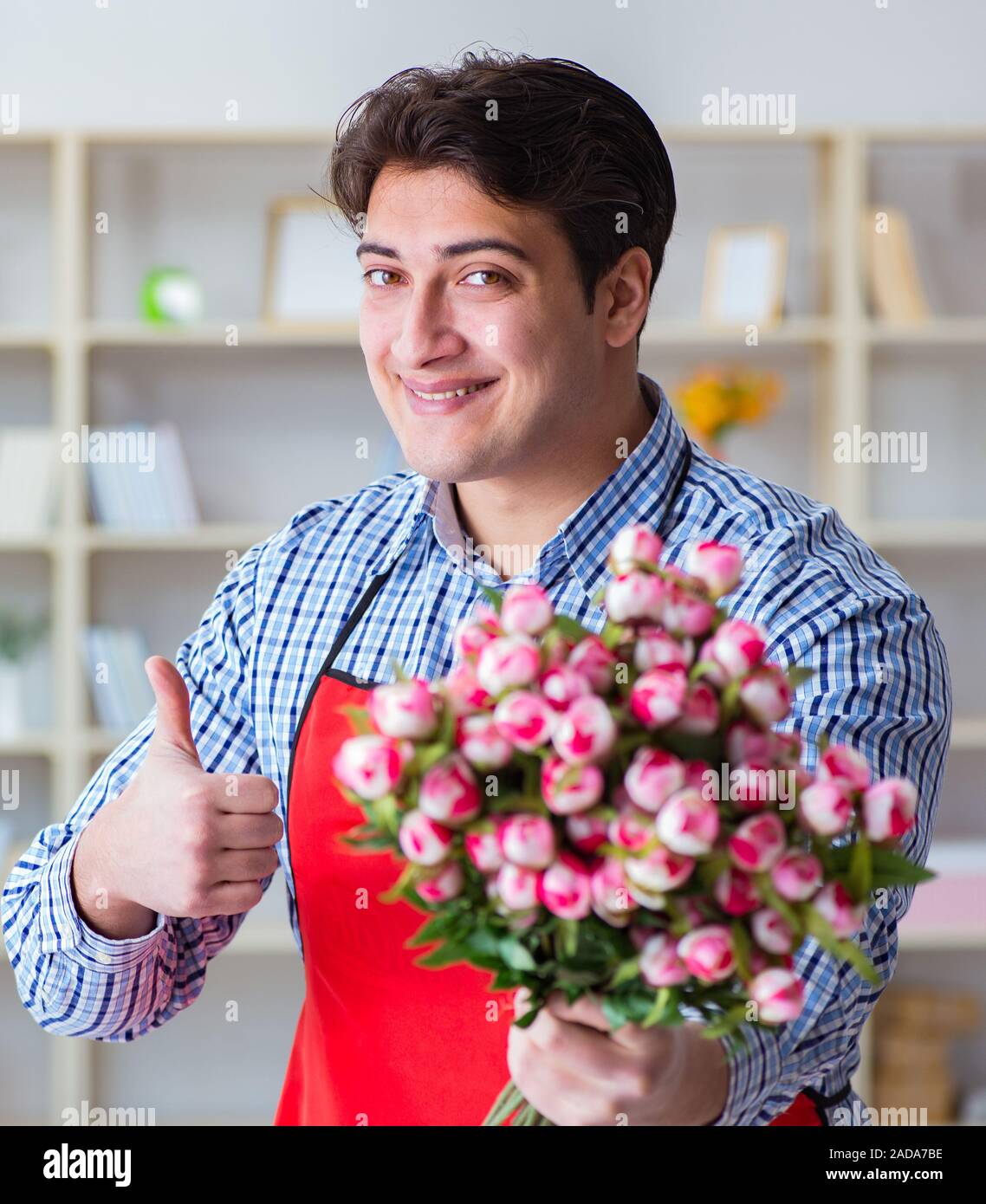 Flower shop assistant offering a bunch of flowers Stock Photo - Alamy