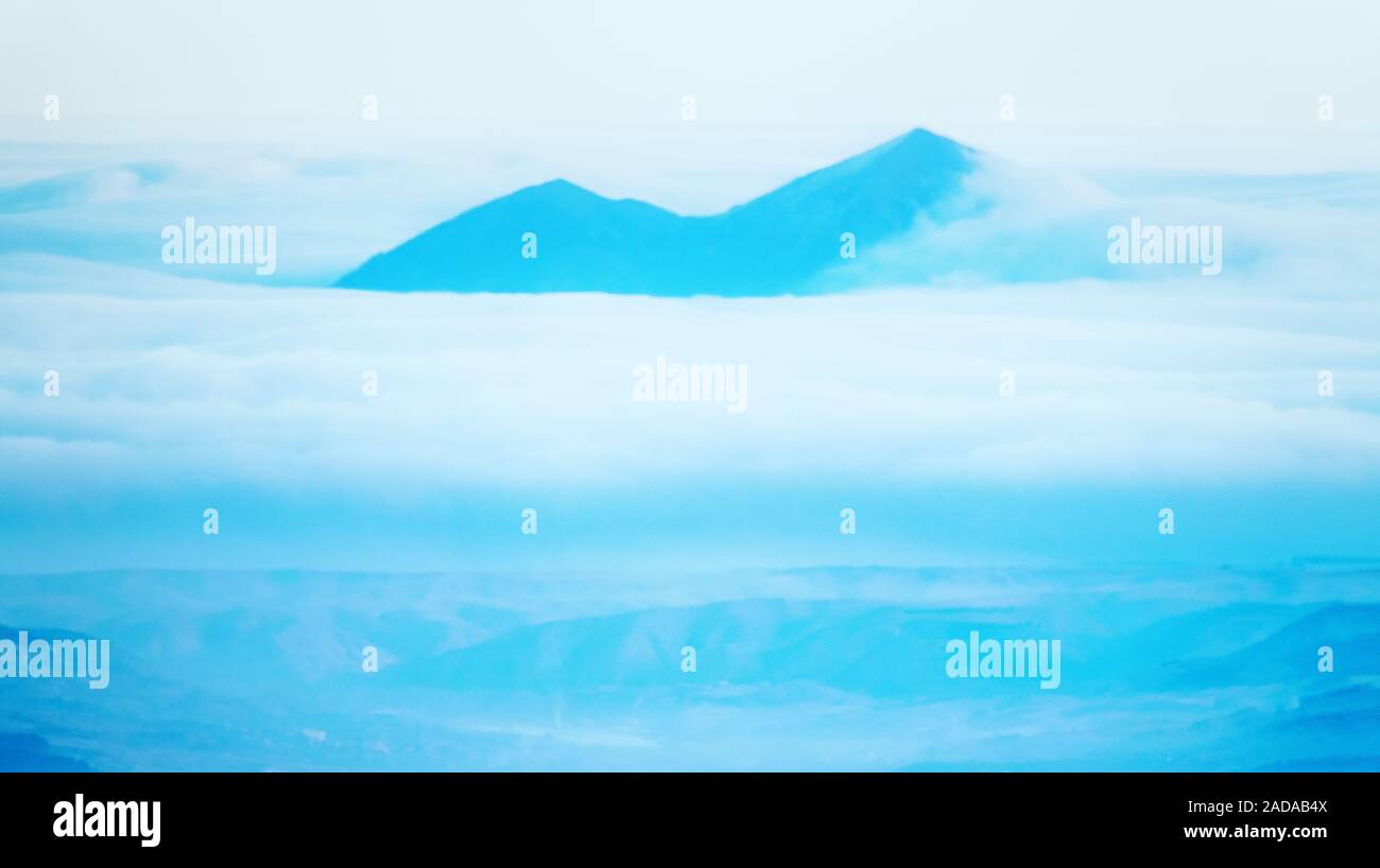 Mountain top sticking out of the clouds Stock Photo - Alamy
