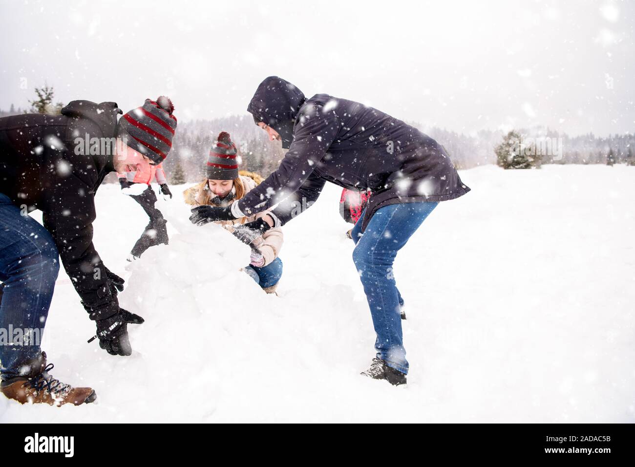 Group young people building snowman hi-res stock photography and images ...