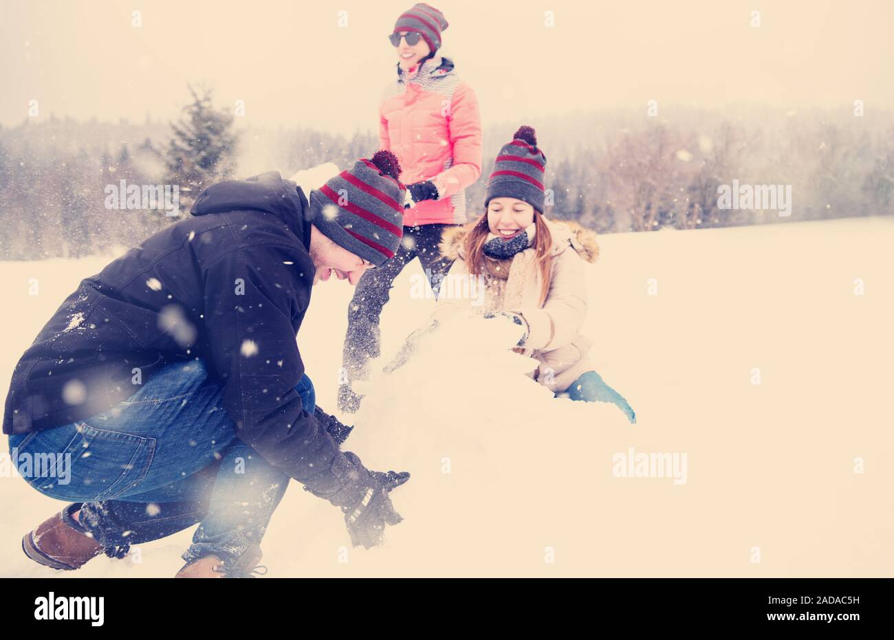 Friends building a snow man hi-res stock photography and images - Alamy