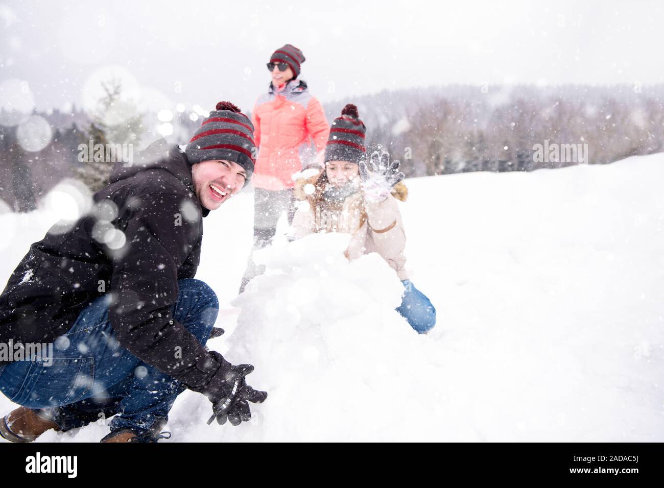 Friends building a snow man hi-res stock photography and images - Alamy