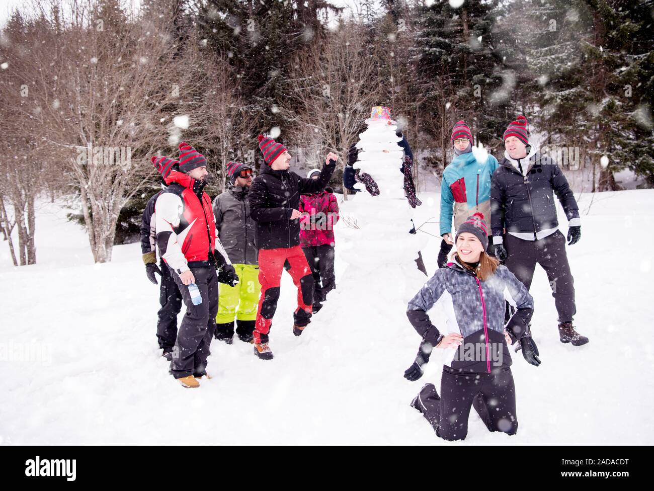 Group young people building snowman hi-res stock photography and images ...