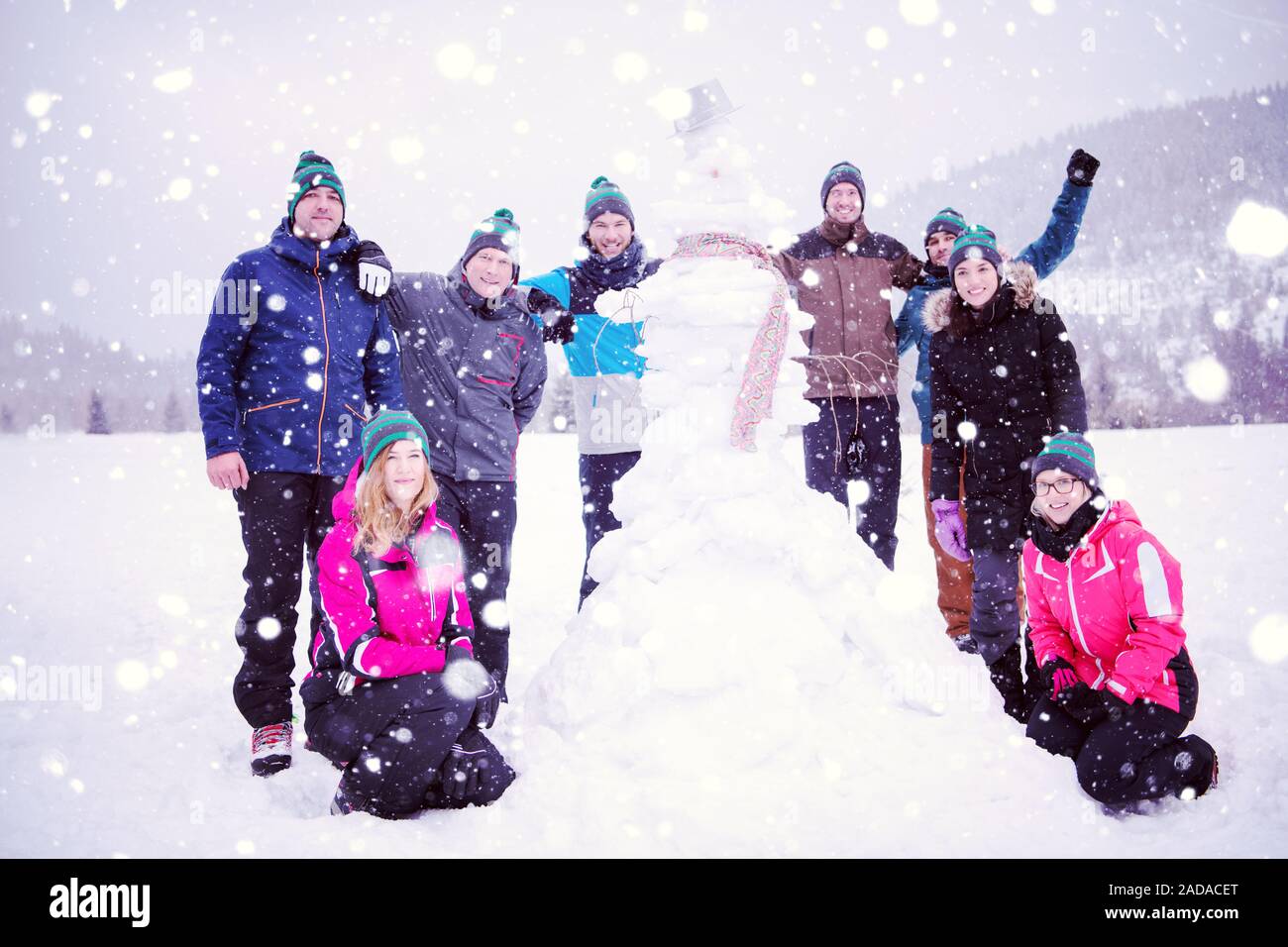 Group young people building snowman hi-res stock photography and images ...