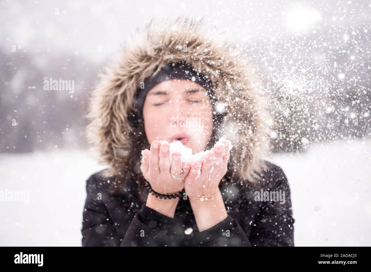 young woman blowing snow on snowy day Stock Photo - Alamy
