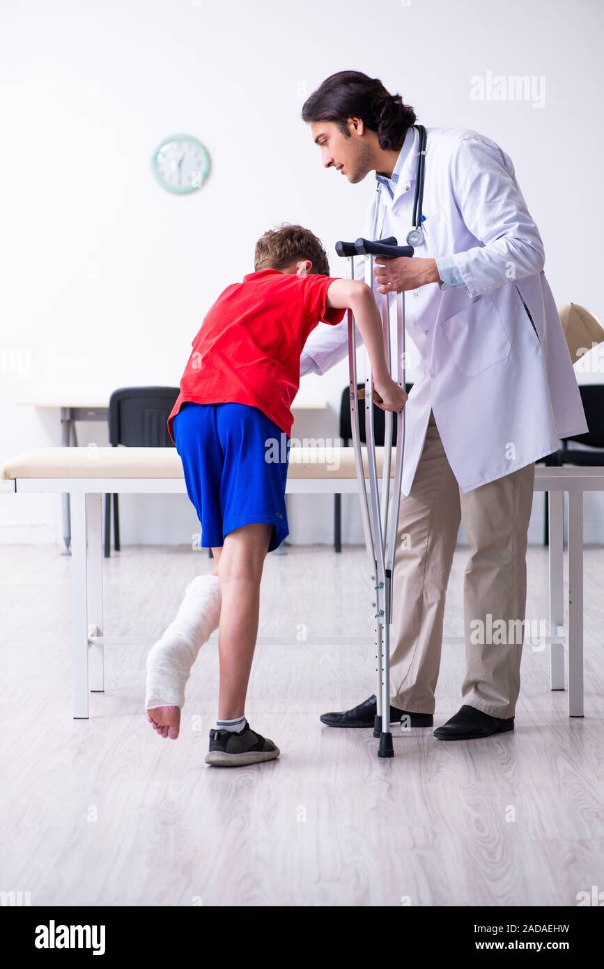 Leg injured boy visiting young doctor traumatologist Stock Photo - Alamy