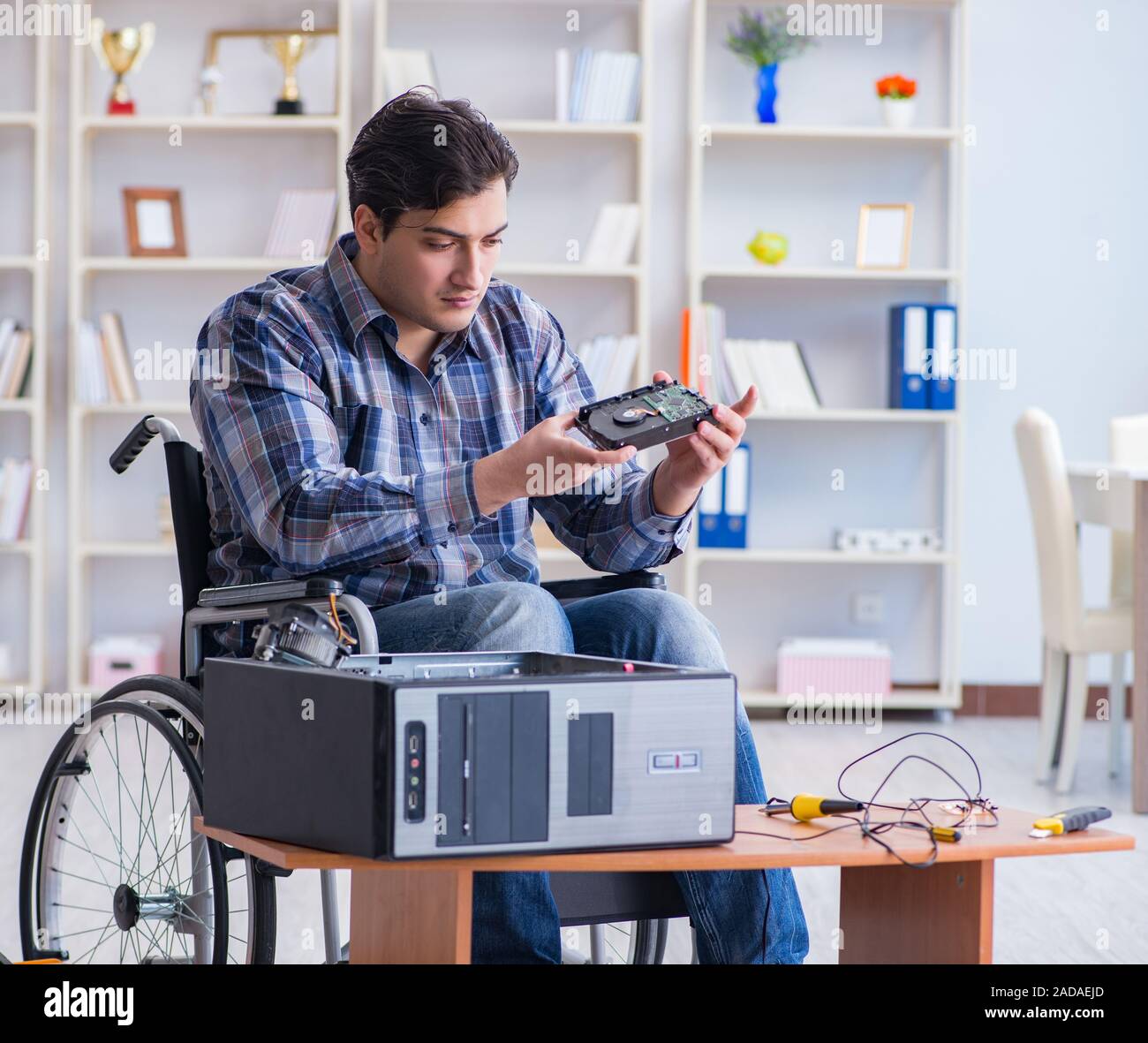 Computer repairman on wheelchair working Stock Photo - Alamy