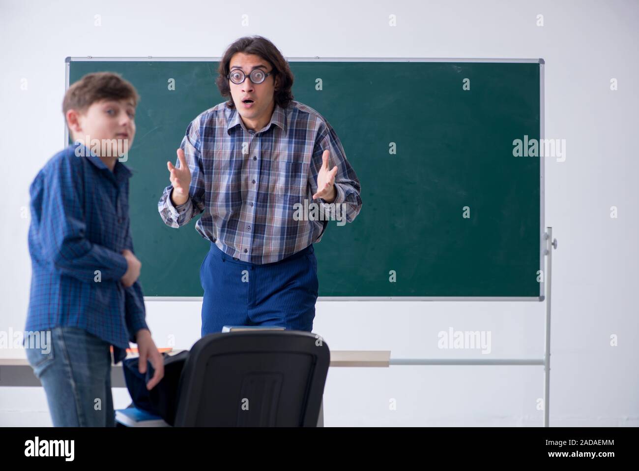 Funny male teacher and boy in the classroom Stock Photo - Alamy