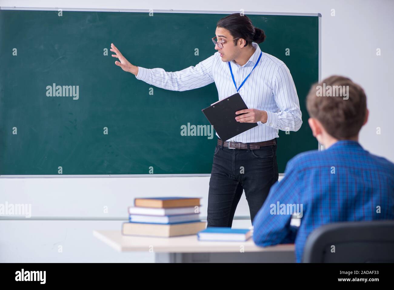 Young male teacher and boy in the classroom Stock Photo - Alamy