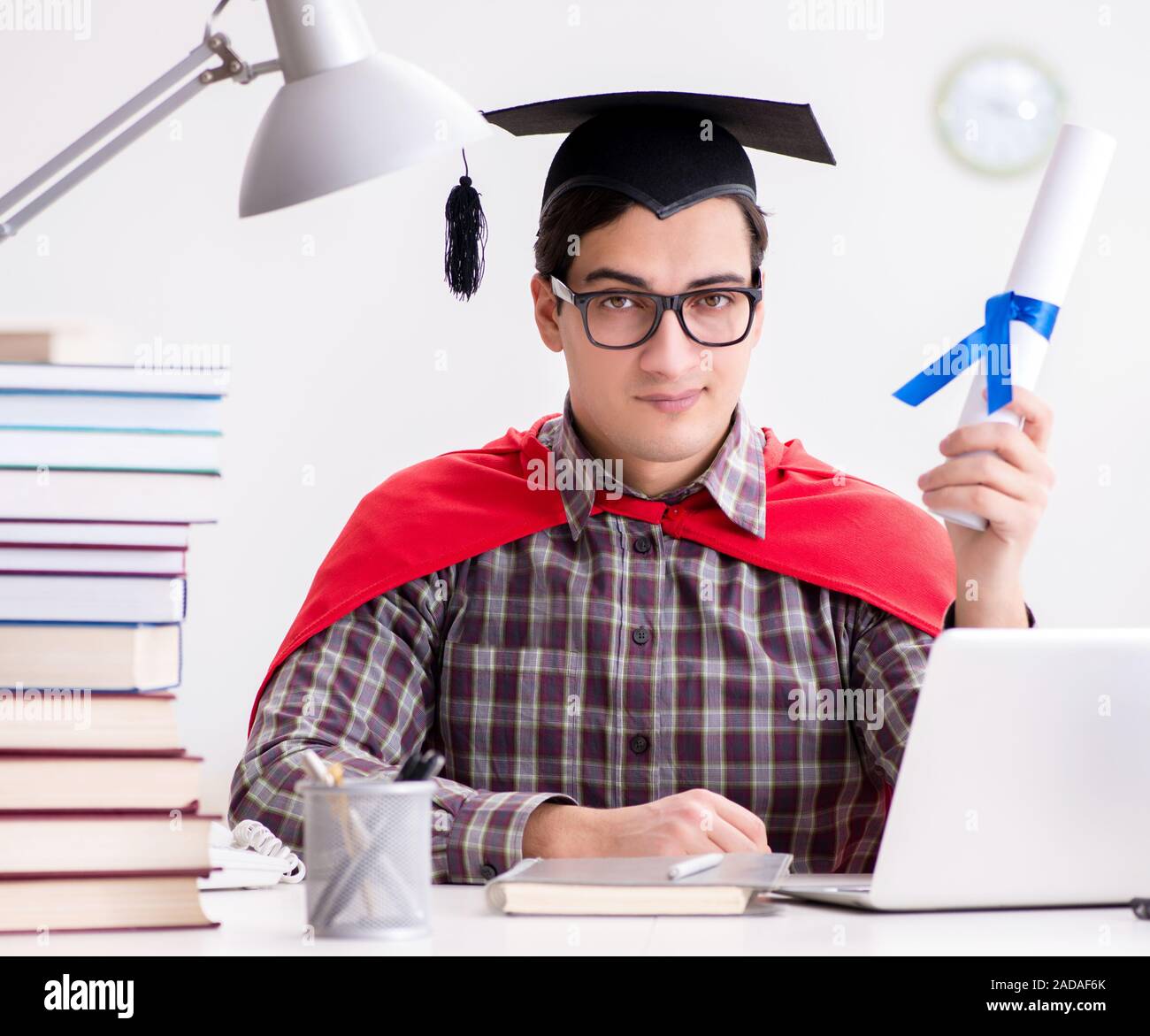 Super hero student wearing a mortarboard studying Stock Photo - Alamy