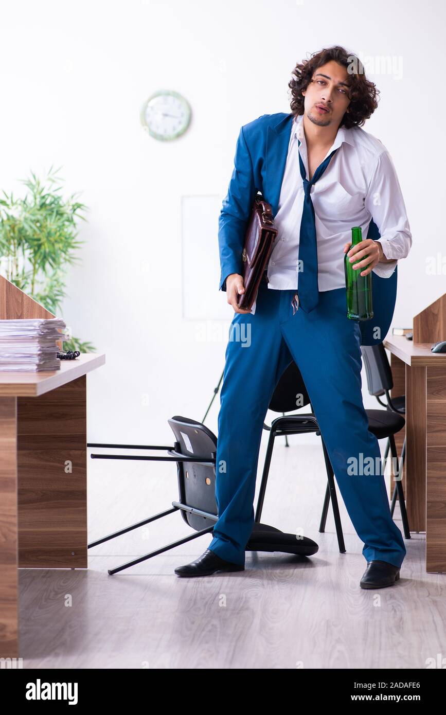 Young drunk employee in the office Stock Photo - Alamy