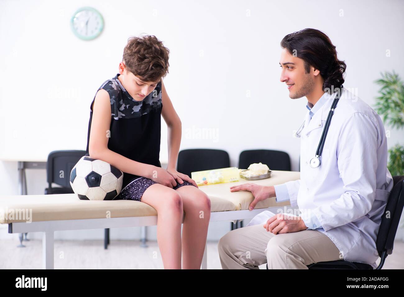 Boy football player visiting young doctor traumatologist Stock Photo ...