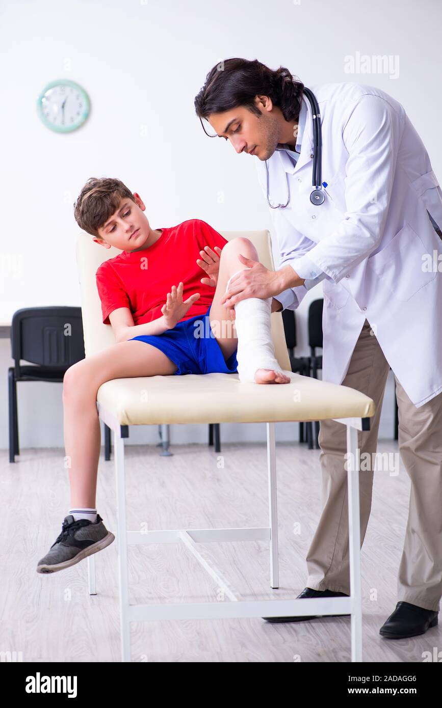 Leg injured boy visiting young doctor traumatologist Stock Photo - Alamy