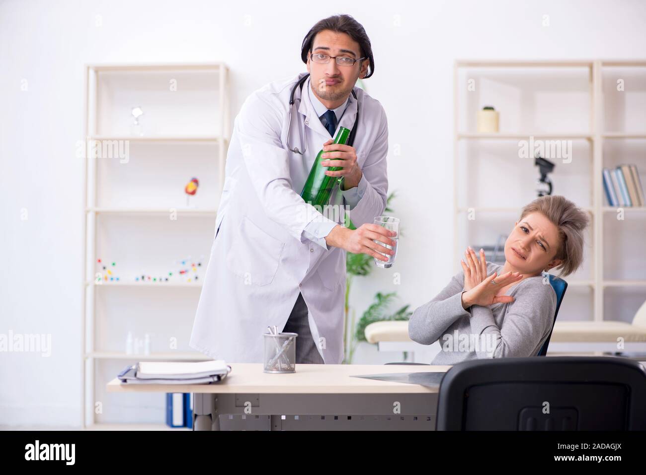 Female alcoholic visiting young male doctor Stock Photo - Alamy