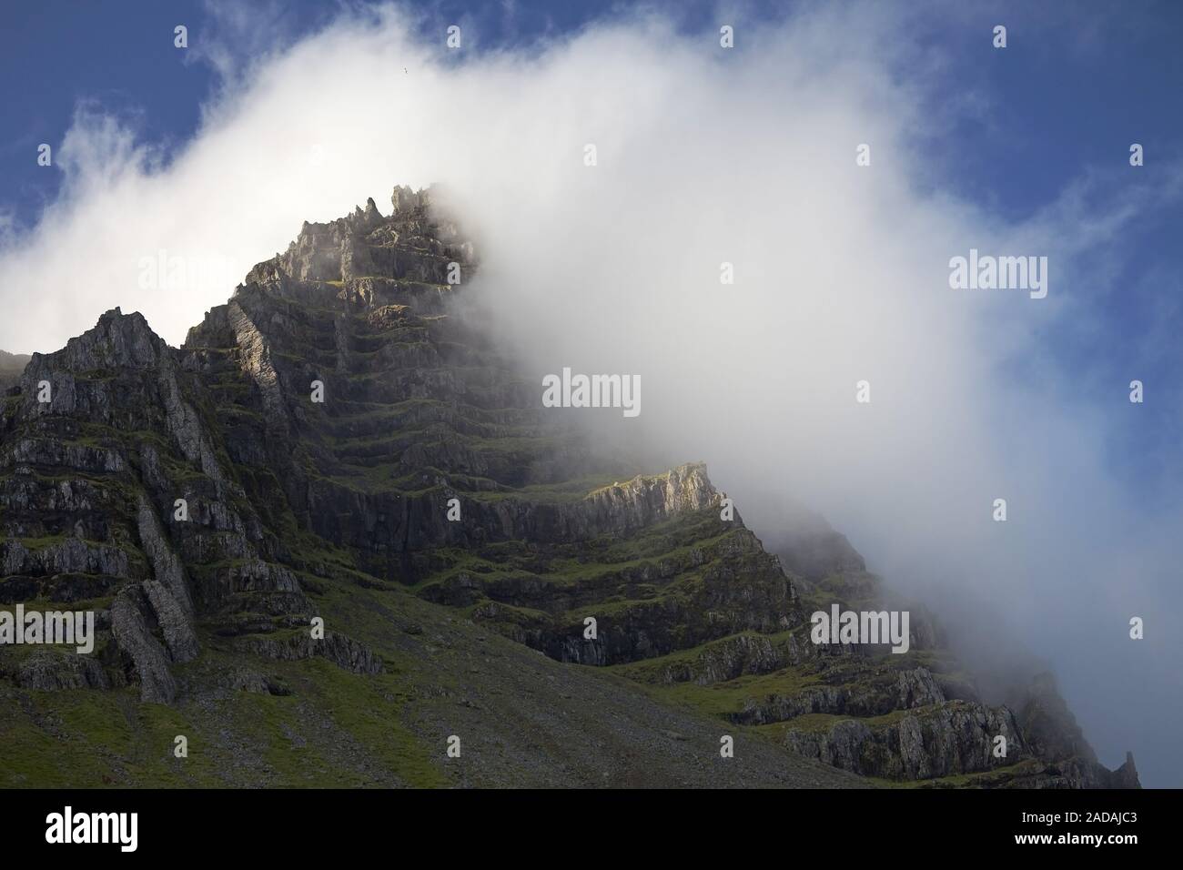 clouds in front of blue sky at the mountain Mosfell, East Iceland ...