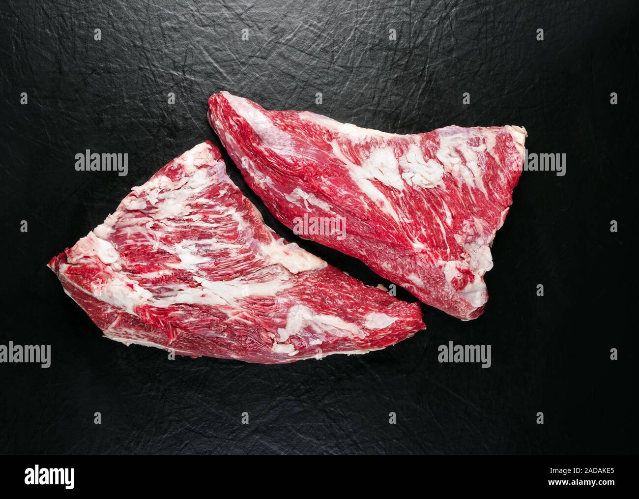 Raw wagyu bavette steak as closeup on black background with copy space ...