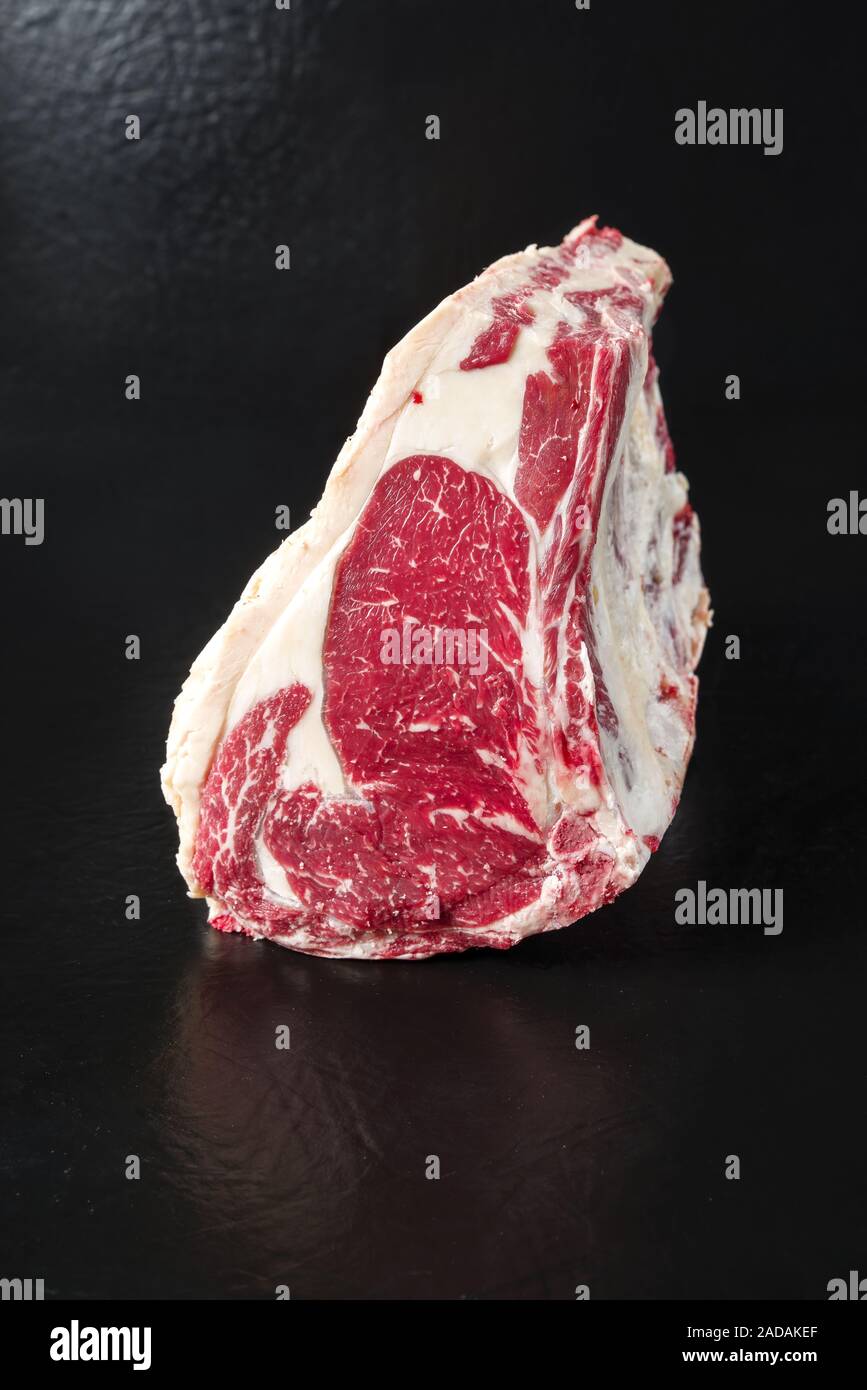 Raw dry aged wagyu cote de boeuf beef block as closeup on black ...
