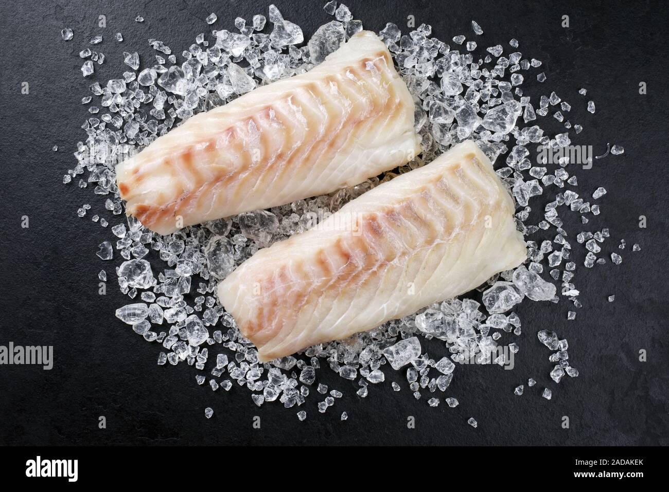 Raw Norwegian skrei cod fish filet as top view on crashed ice on a ...