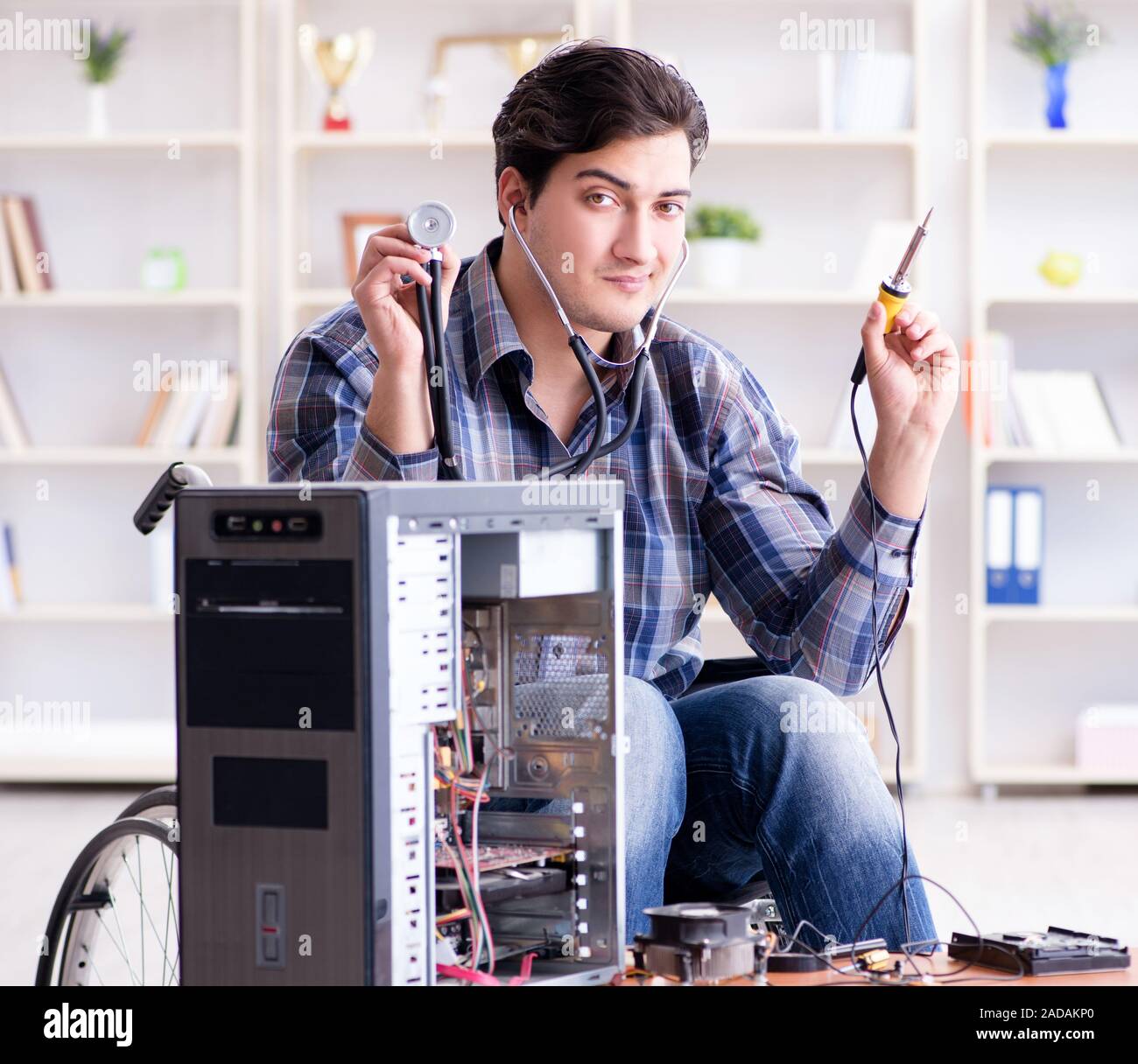 Disabled man on wheelchair repairing computer Stock Photo - Alamy