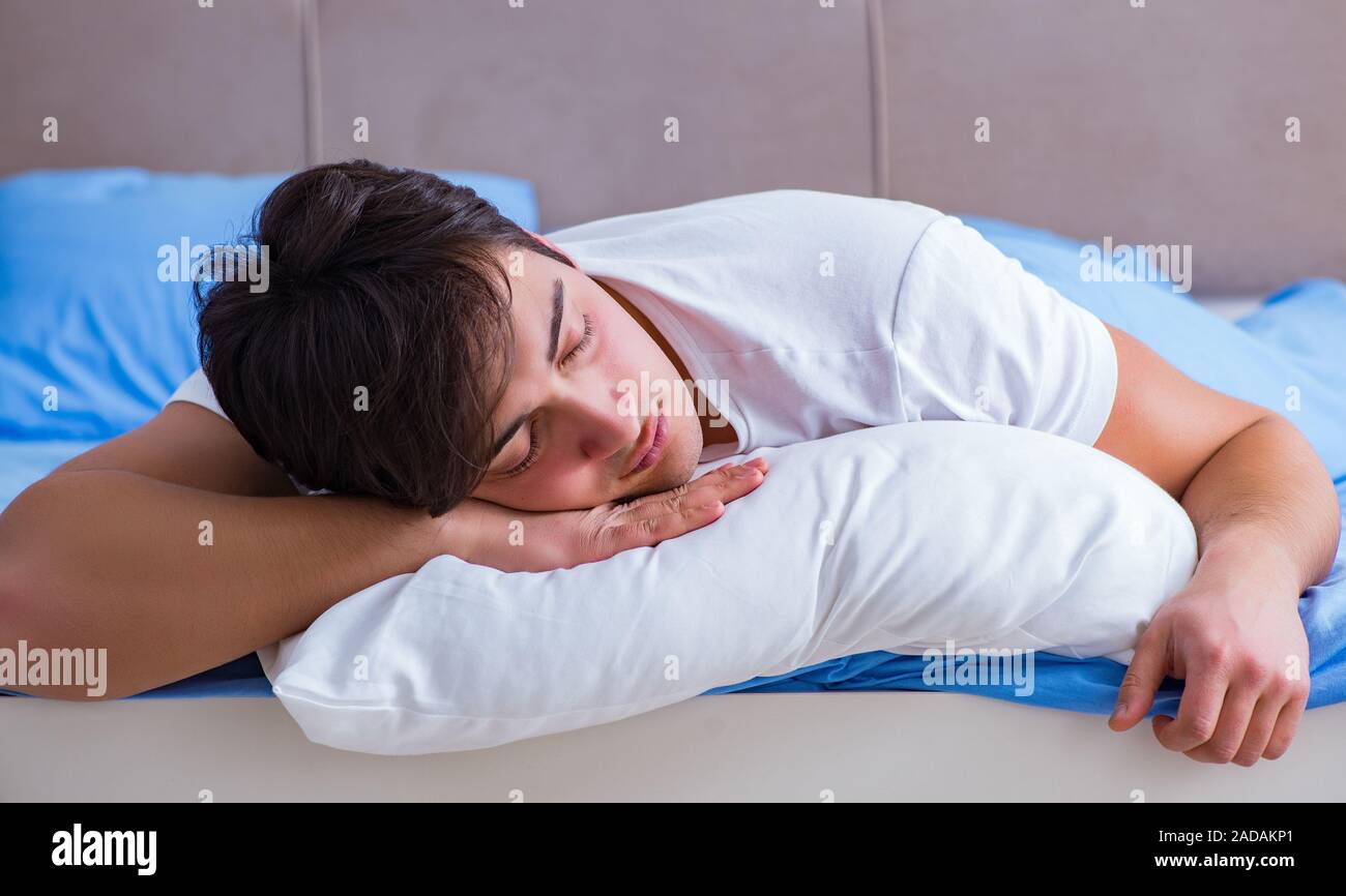 Man suffering from insomnia lying in bed Stock Photo - Alamy