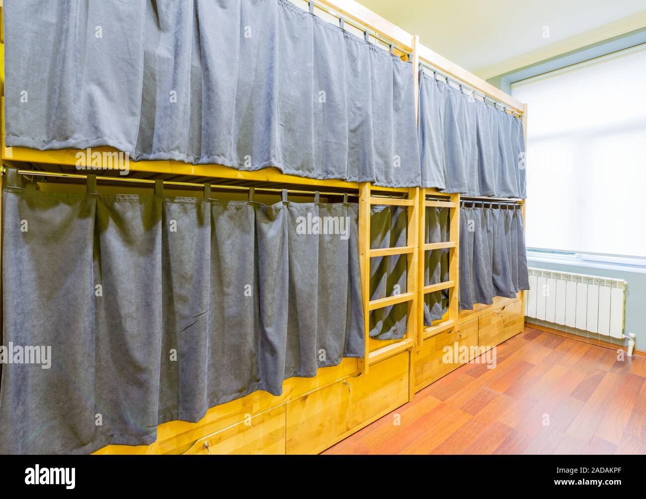Hostel dormitory beds arranged in room Stock Photo - Alamy