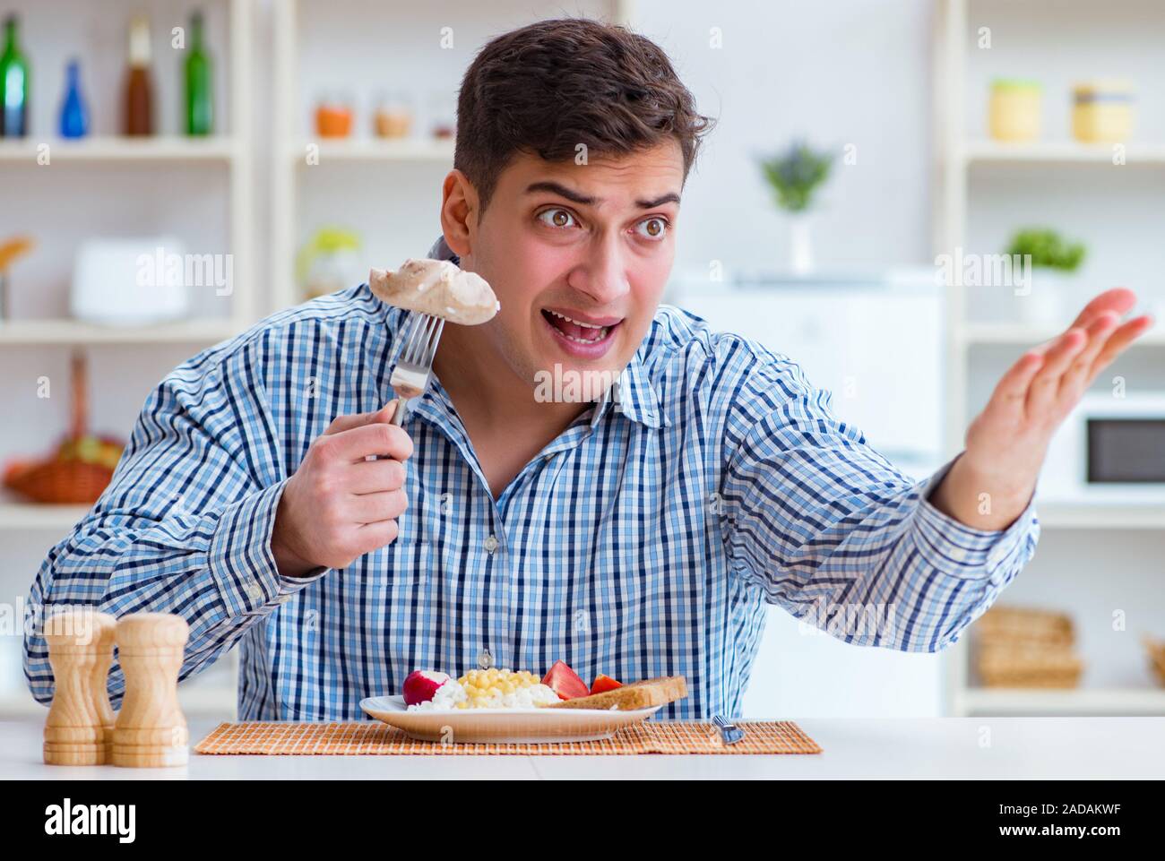 Man eating tasteless food at home for lunch Stock Photo - Alamy