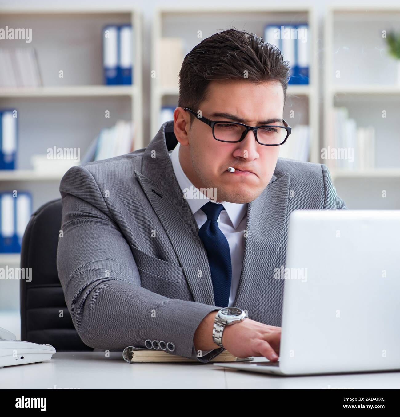 Businessman smoking in office at work Stock Photo - Alamy