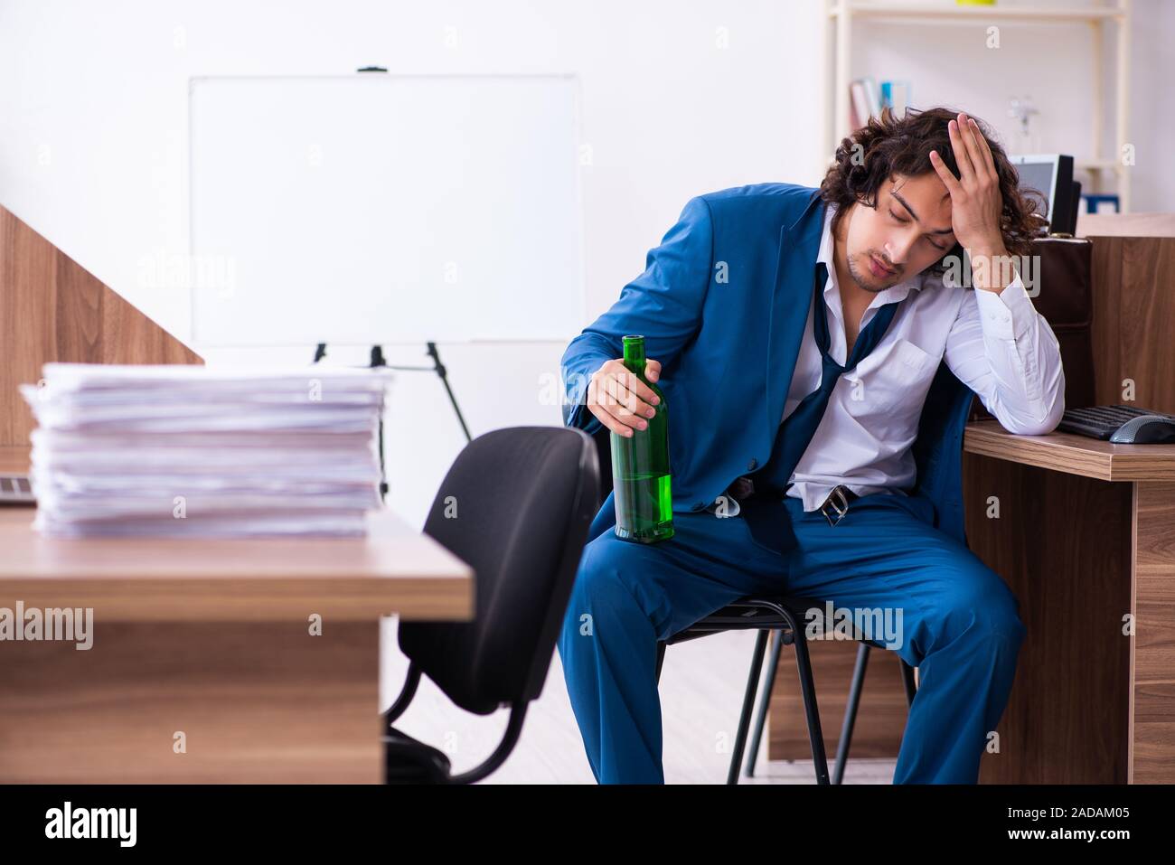 Young drunk employee in the office Stock Photo - Alamy