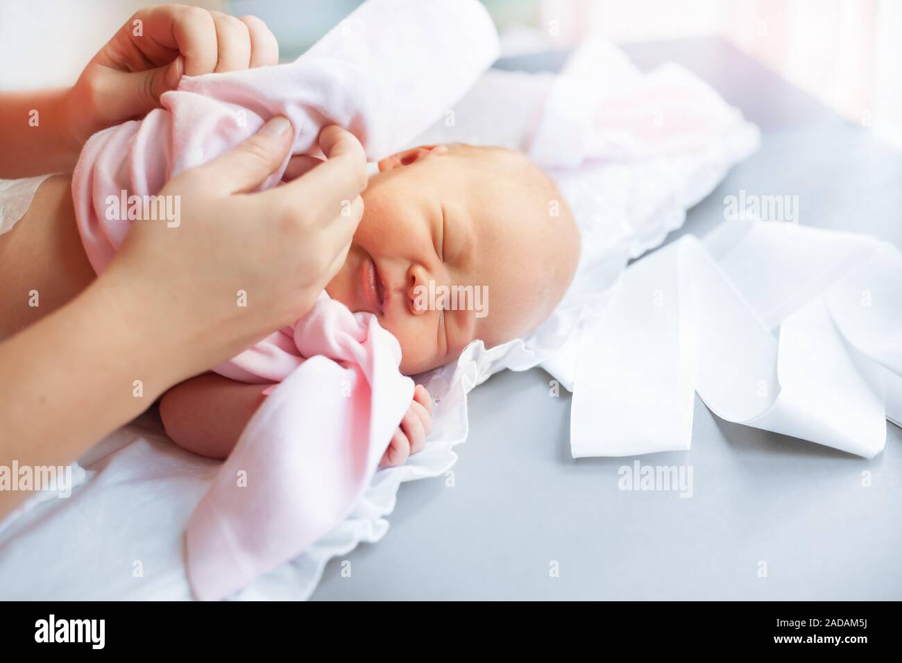 Newborn baby in a diaper on the changing table in the delivery room of ...