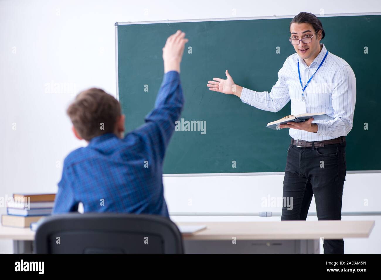 Young male teacher and boy in the classroom Stock Photo - Alamy