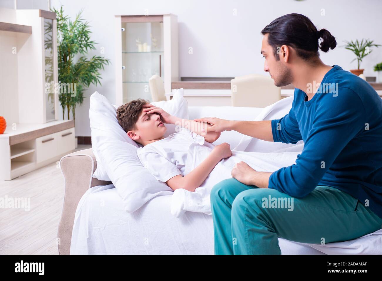 Young father caring for sick son Stock Photo - Alamy