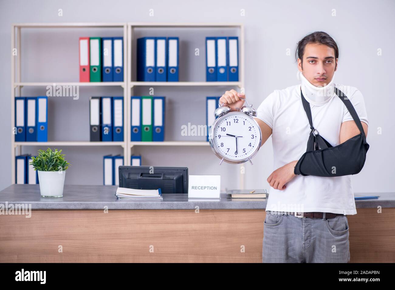Young man at hospital reception desk Stock Photo - Alamy