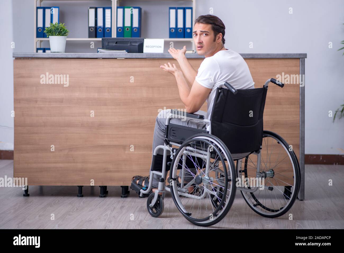 Young man at hospital reception desk Stock Photo - Alamy