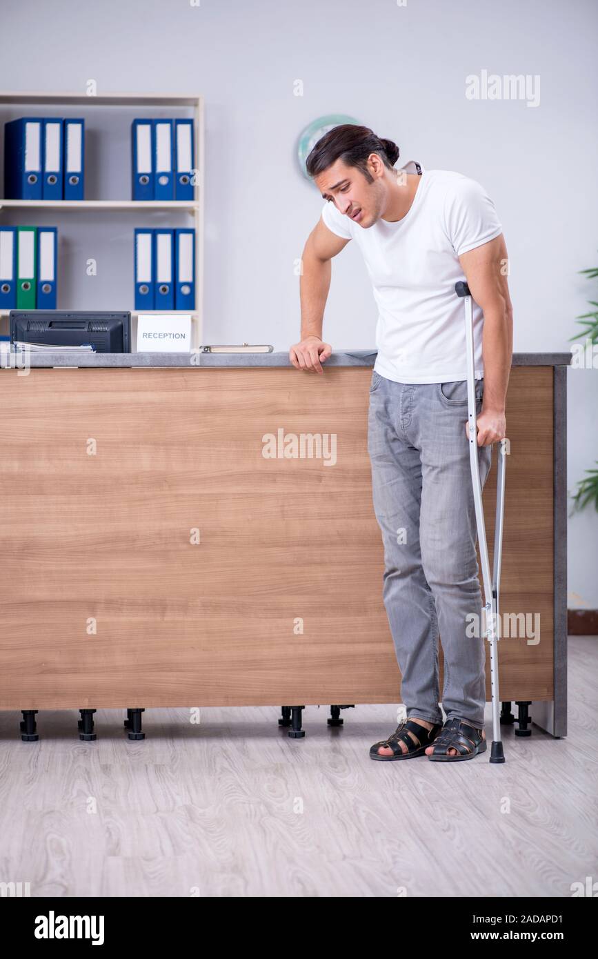 Young man at hospital reception desk Stock Photo - Alamy