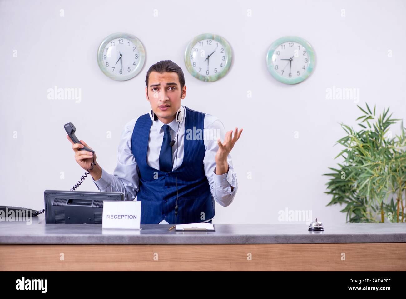Young man receptionist at the hotel counter Stock Photo - Alamy