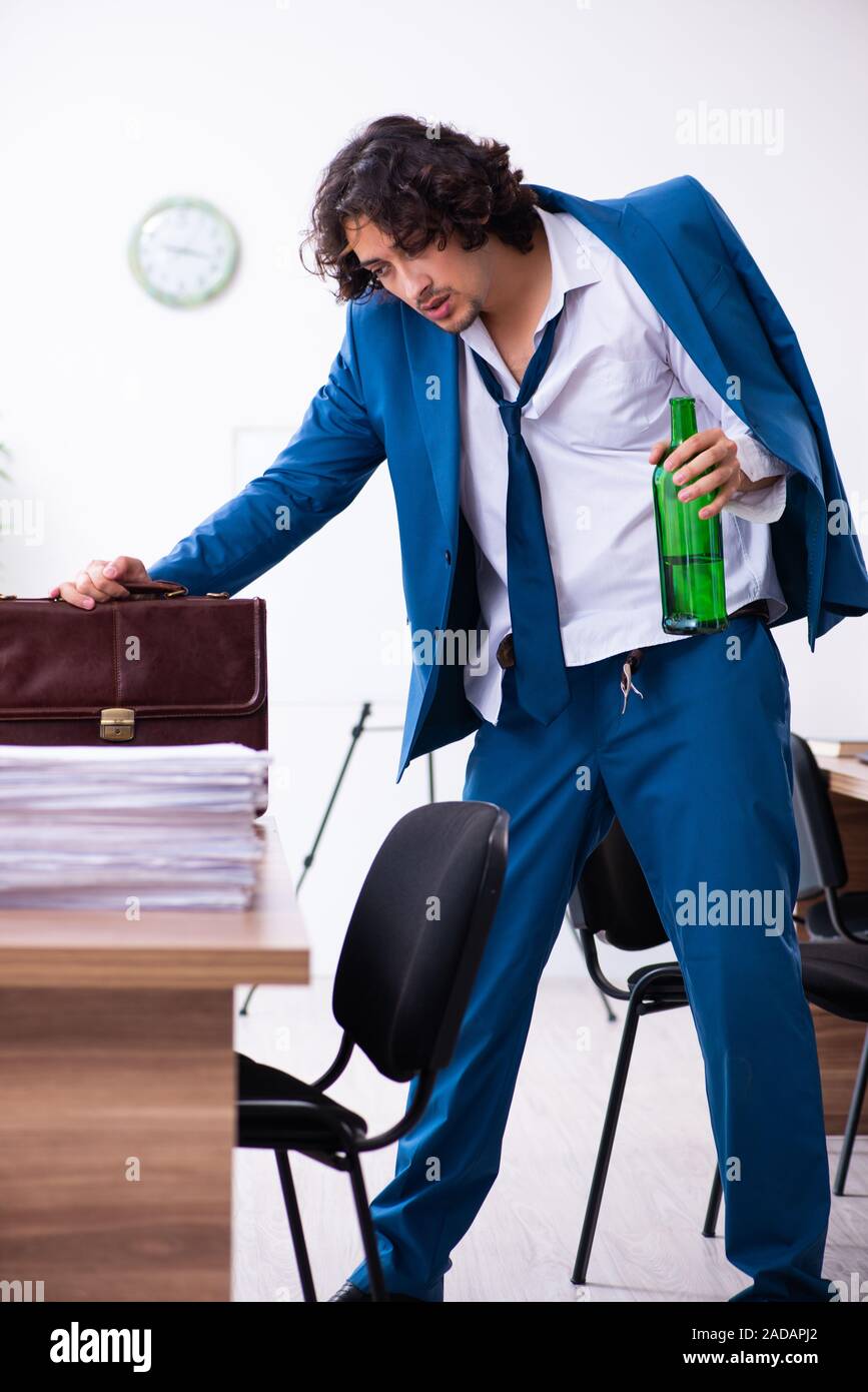 Young drunk employee in the office Stock Photo - Alamy