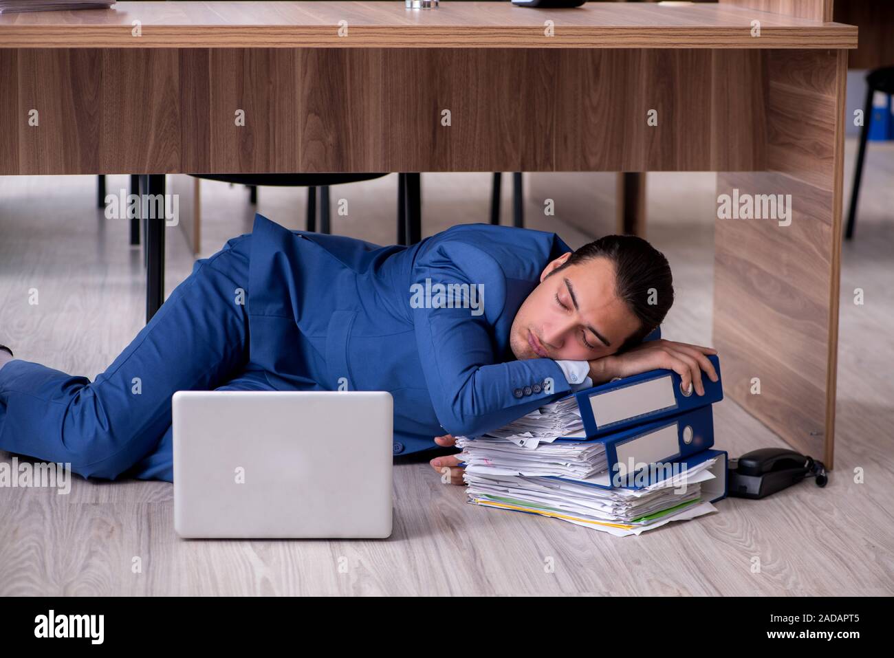 Young male employee and too many work in the office Stock Photo - Alamy