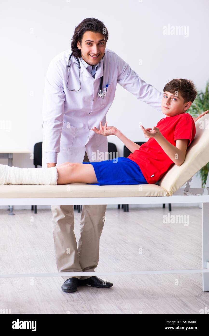Leg injured boy visiting young doctor traumatologist Stock Photo - Alamy