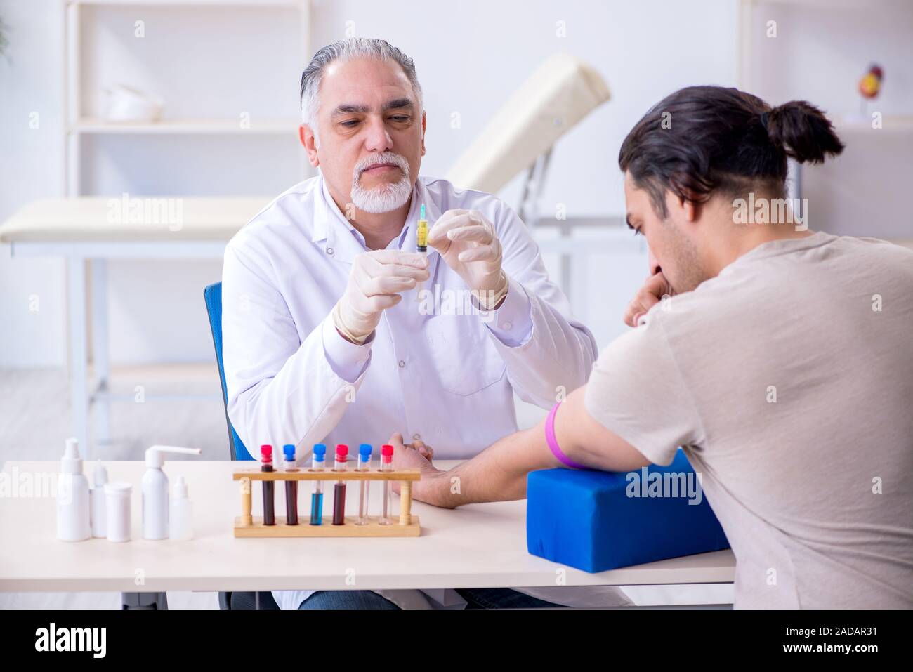 Young man doctor during medical procedure hi-res stock photography and ...