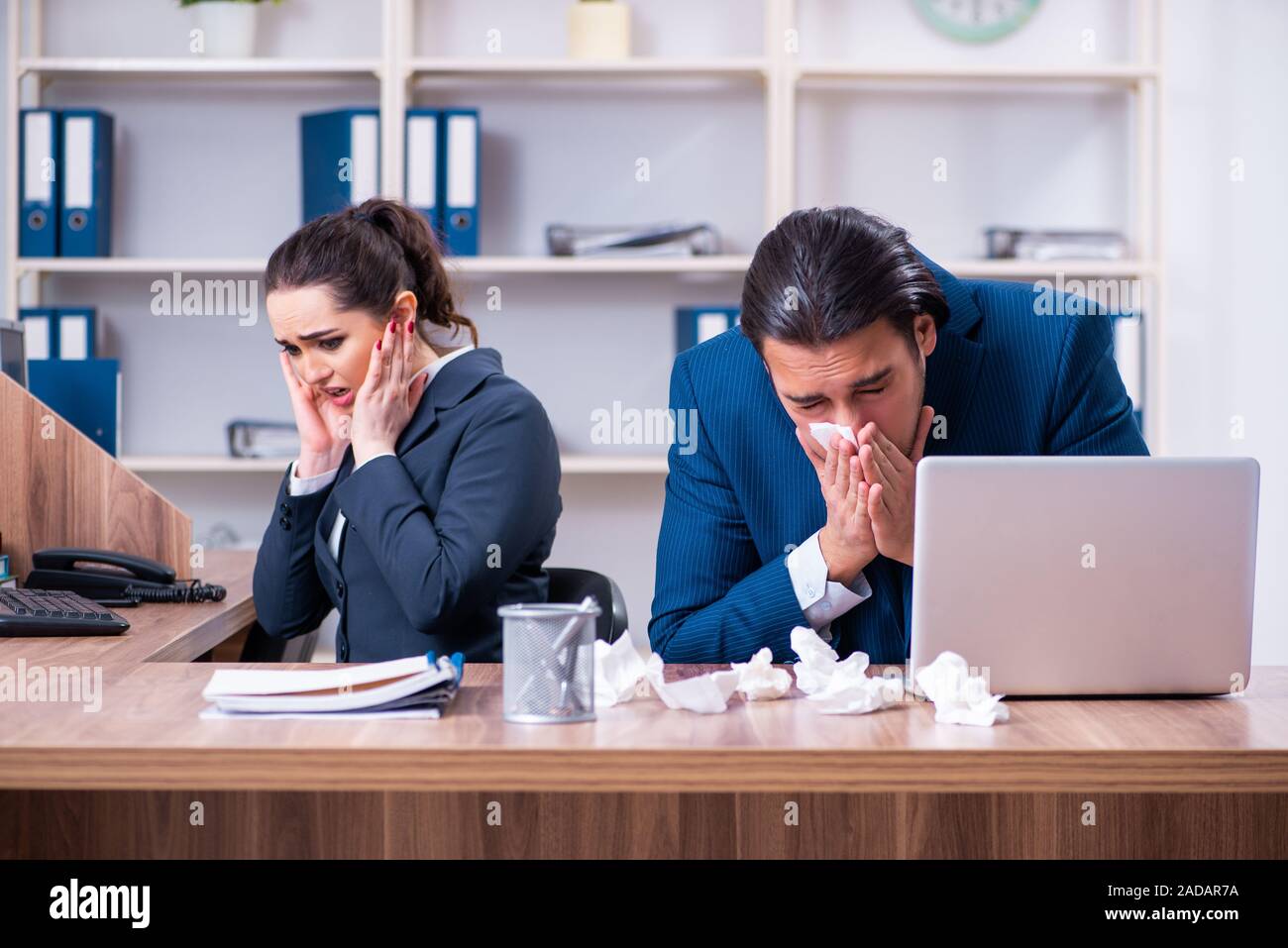 Two employees suffering at workplace Stock Photo - Alamy