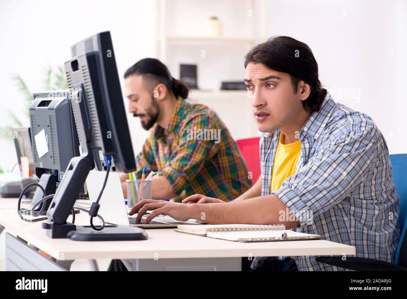 Two it specialists working in the office Stock Photo - Alamy