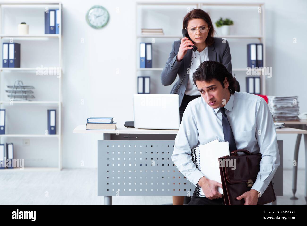 Old female boss and young male employee in the office Stock Photo - Alamy