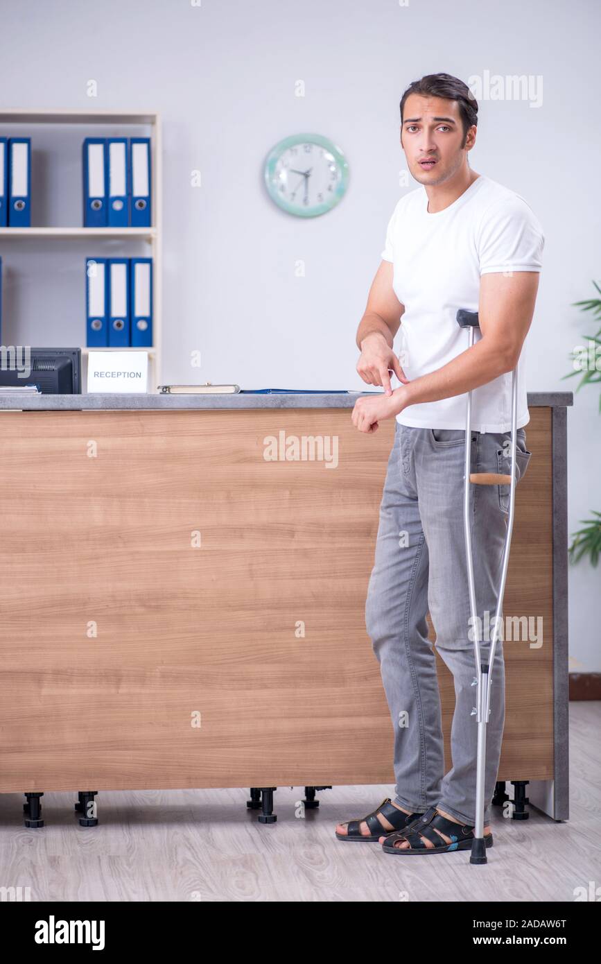 Young man at hospital reception desk Stock Photo - Alamy