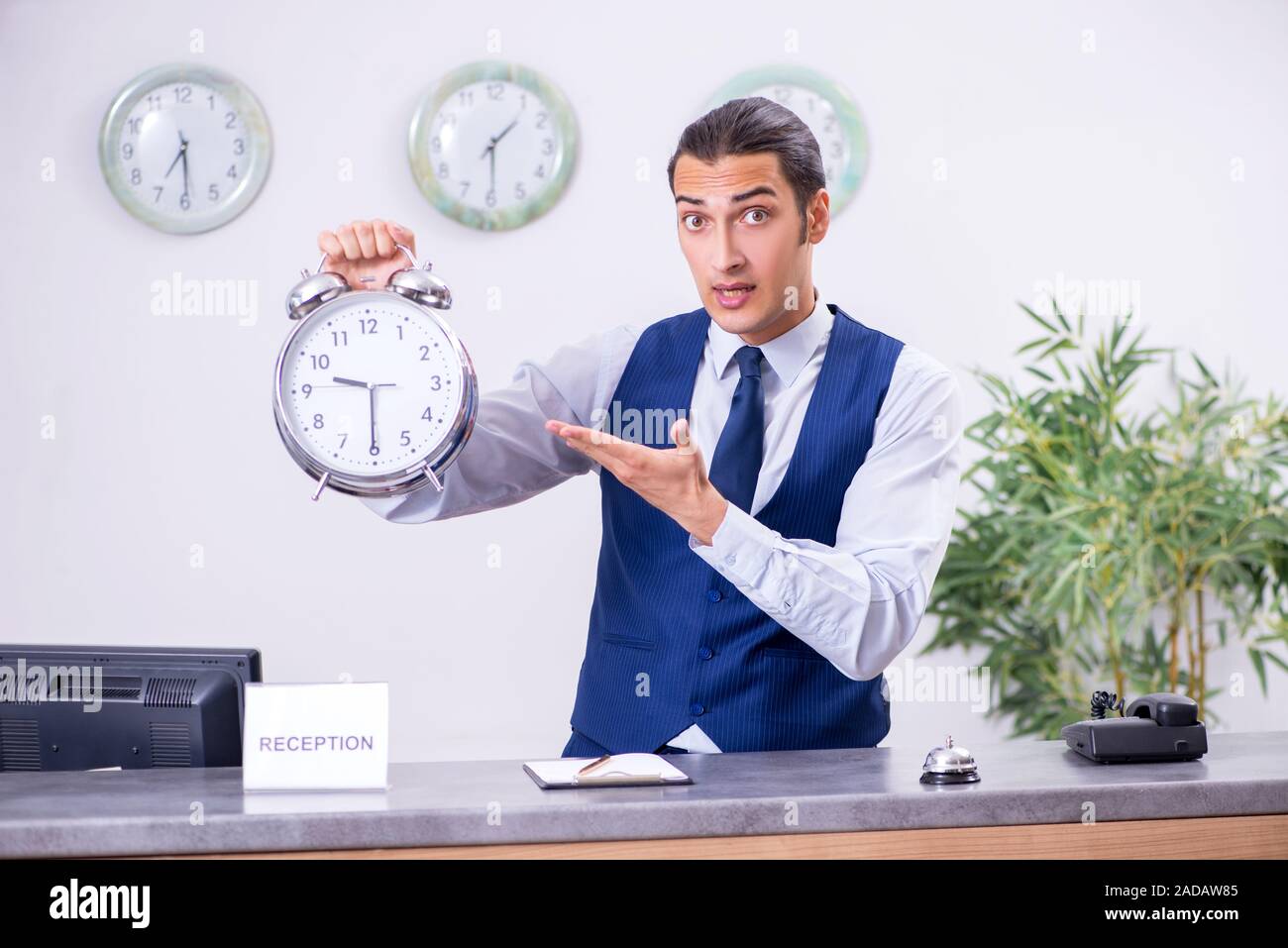 Young man receptionist at the hotel counter Stock Photo - Alamy