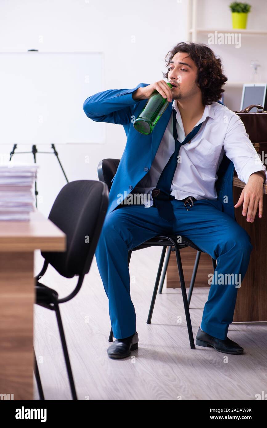 Young drunk employee in the office Stock Photo - Alamy