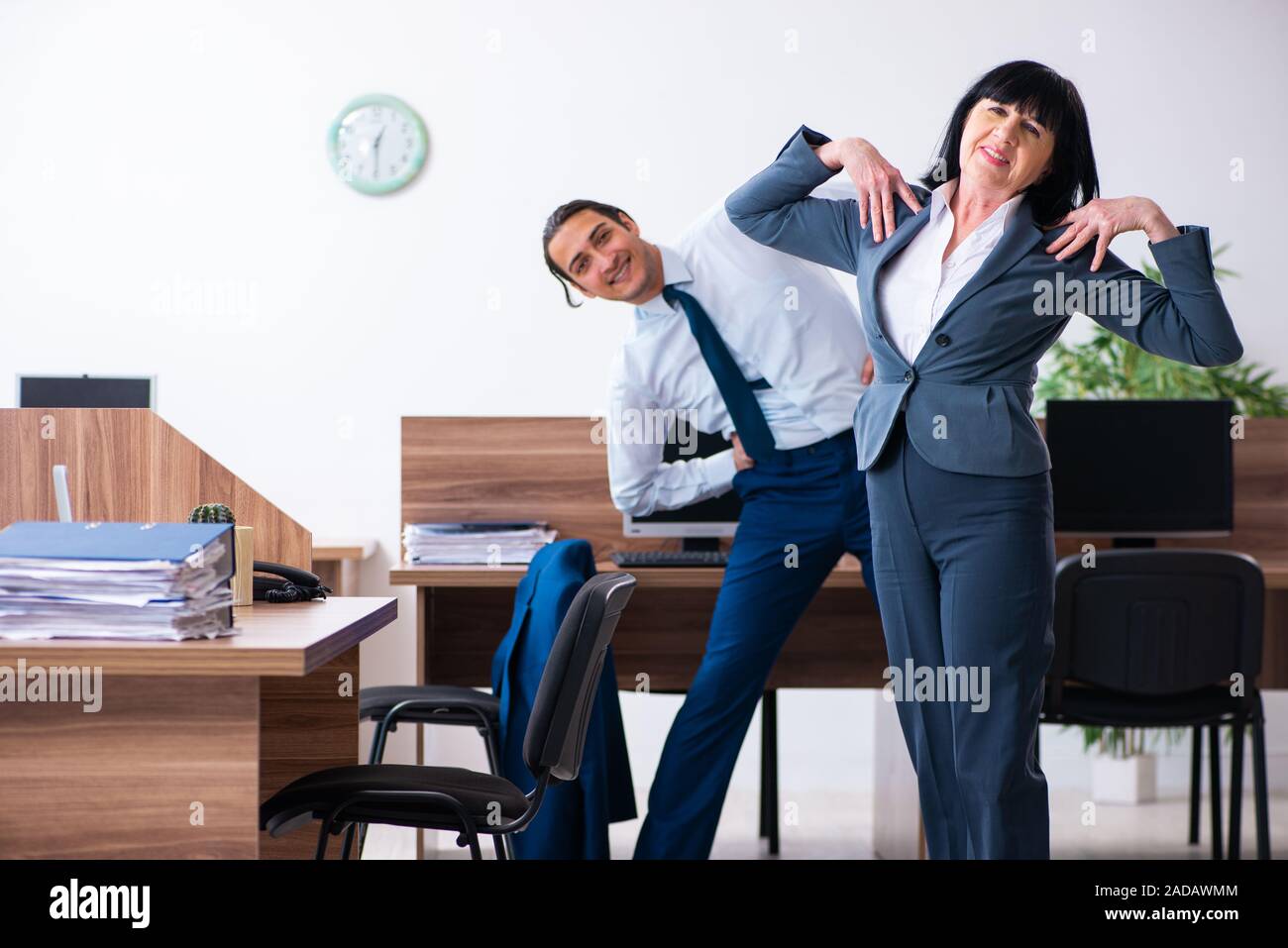 Two employees doing sport exercises in the office Stock Photo - Alamy