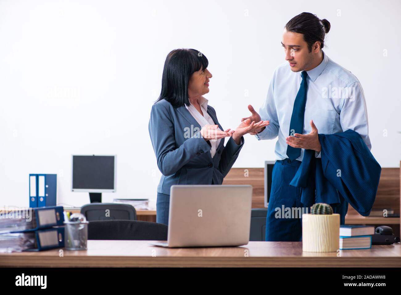 Two employees doing sport exercises in the office Stock Photo - Alamy