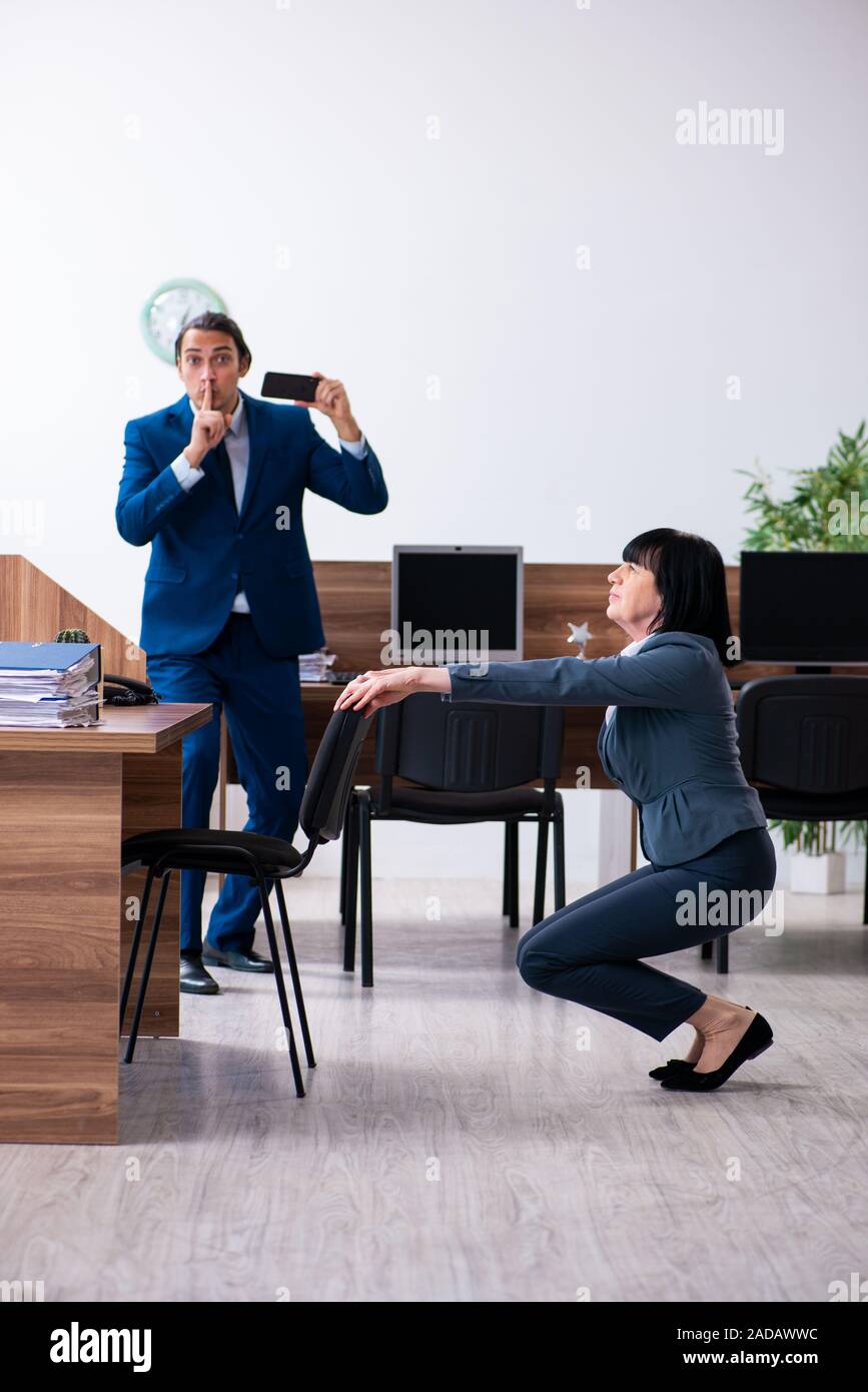 Two employees doing sport exercises in the office Stock Photo - Alamy